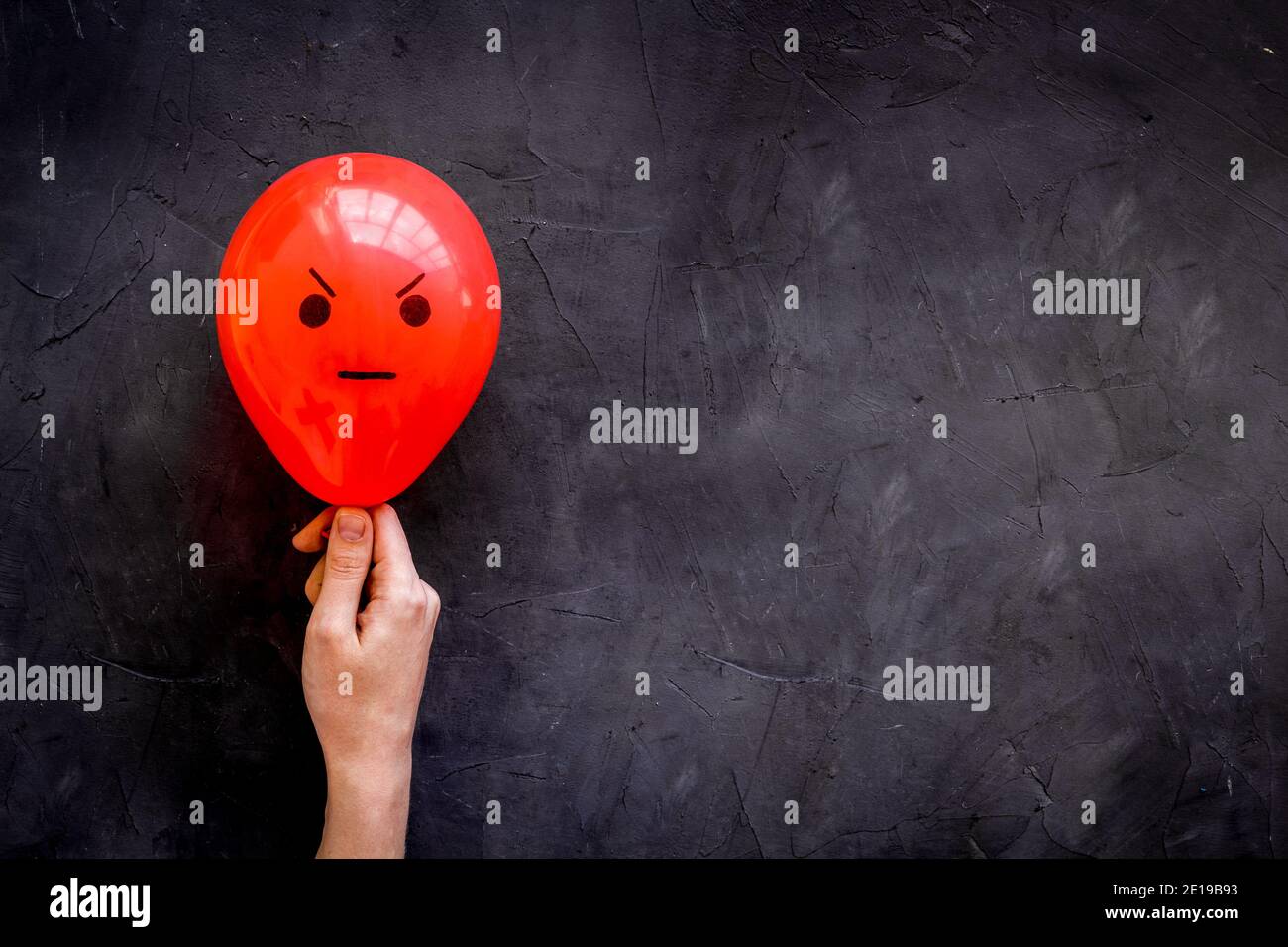 Anger emotion face on balloon - madness mood background. Top view, copy ...