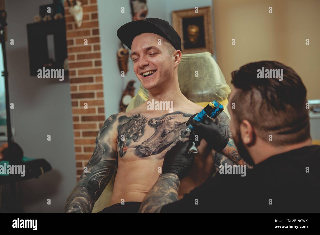 Young handsome cheerful man laughing joyfully, talking to his tattoo ...