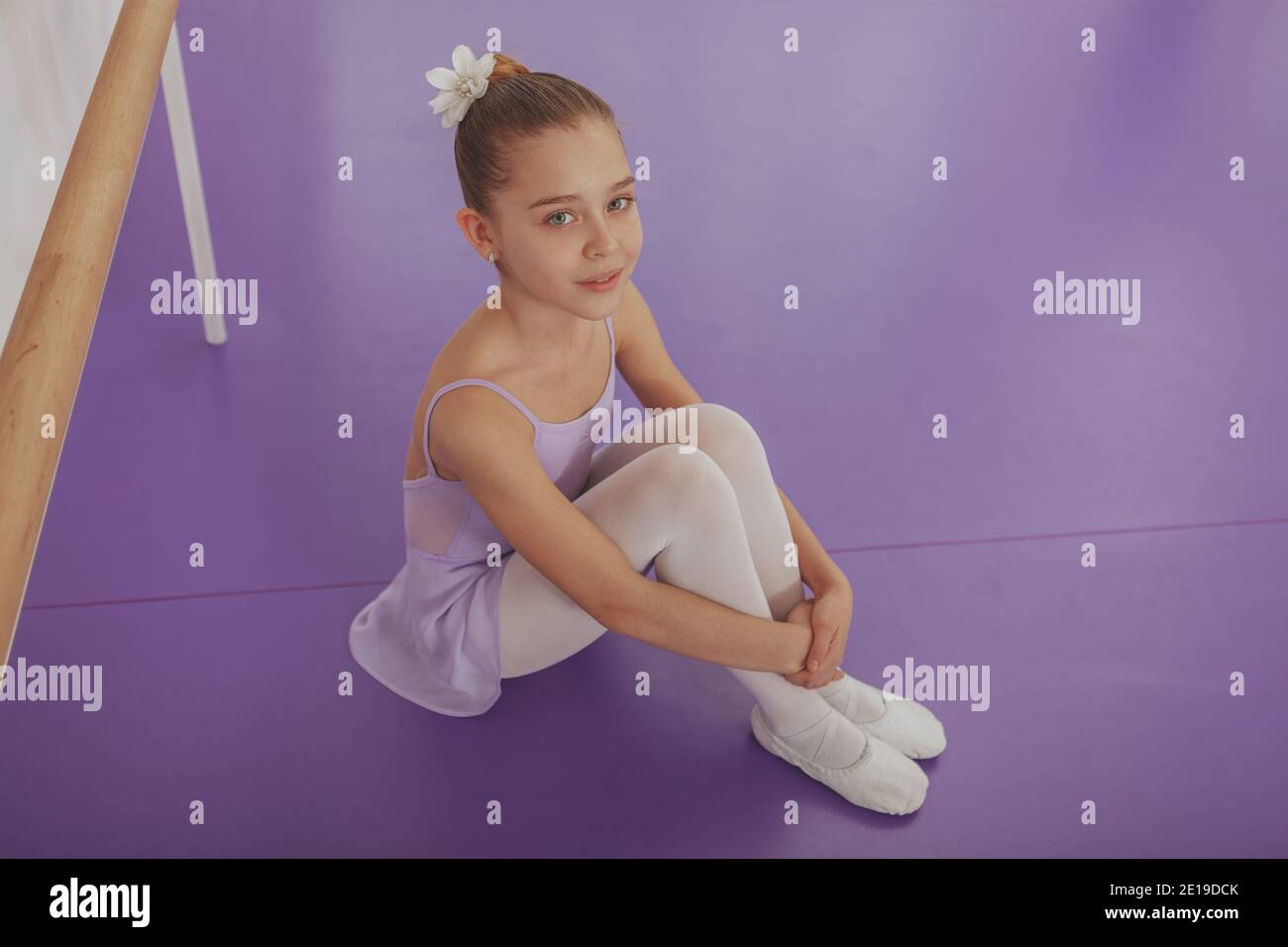 Top view shot of a charming young ballerina girl smiling to the camera ...