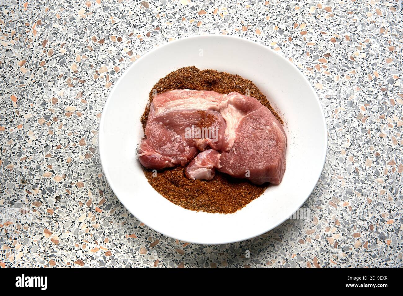 A piece of spiced meat in a plate before frying Stock Photo - Alamy