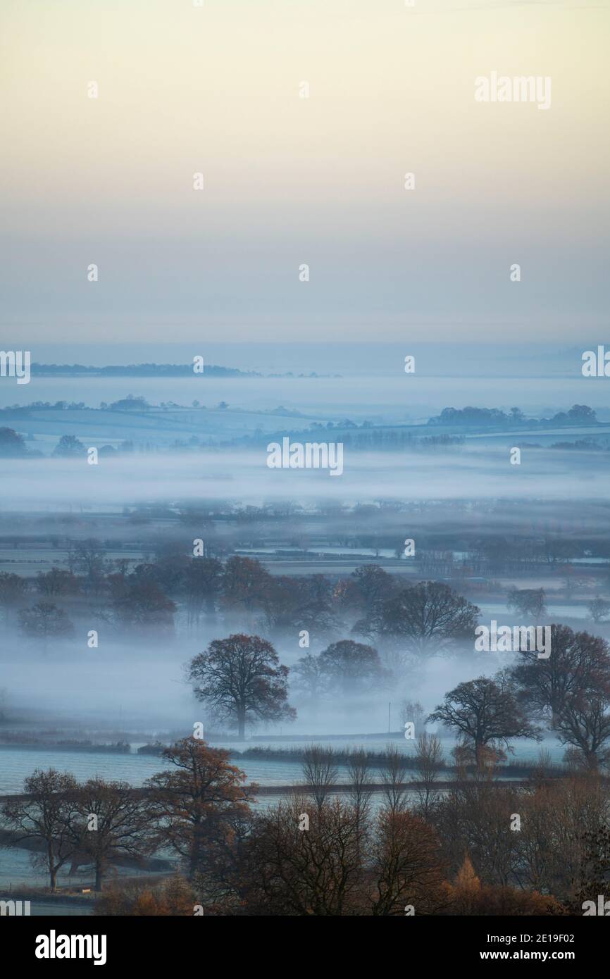 Misty blue landscape view of English countryside with mist layers ...