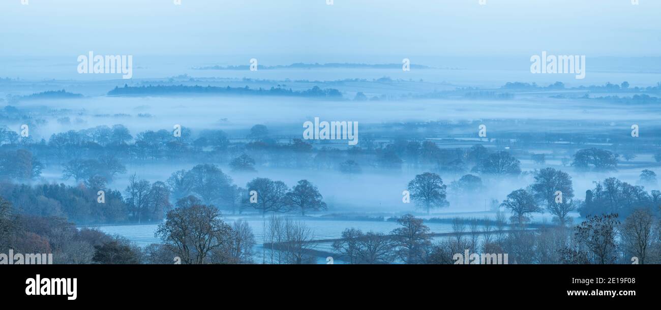 Misty blue landscape view of English countryside with mist layers ...