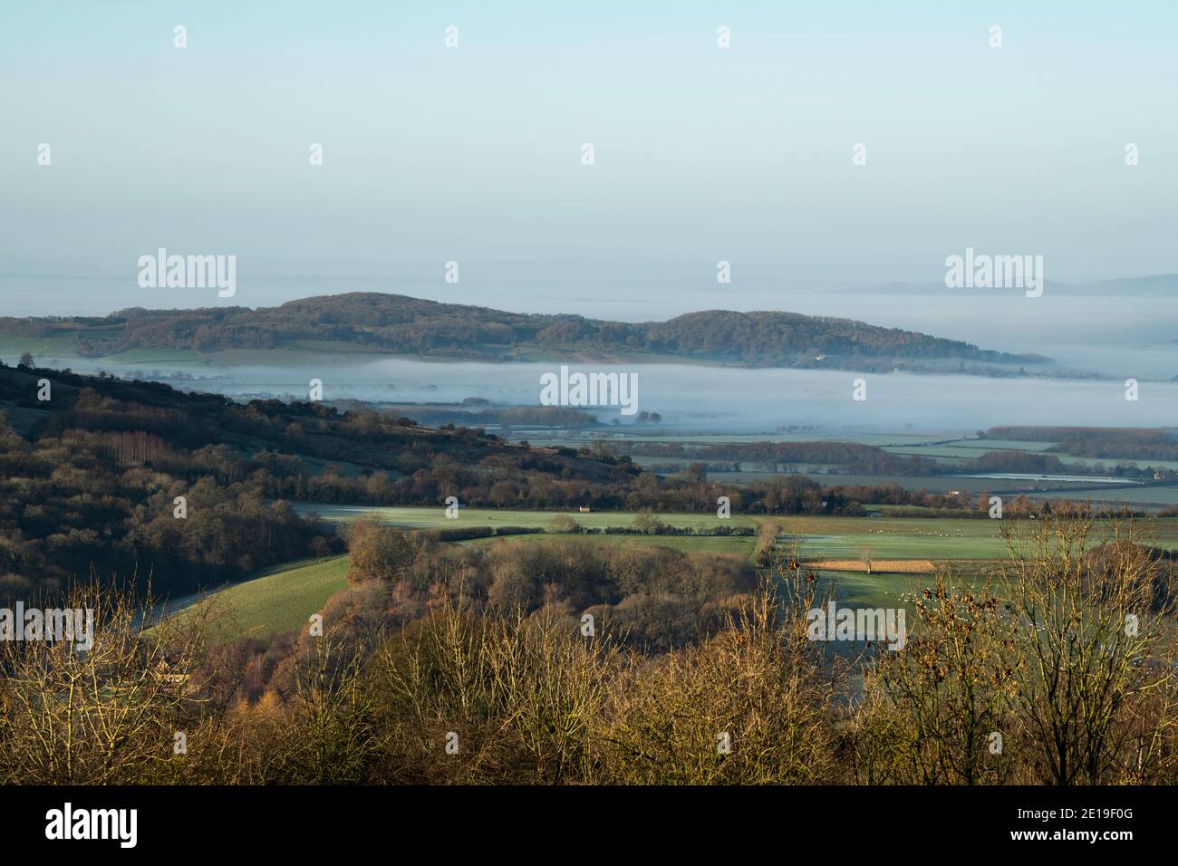 Layers of mist in a valley in the countryside with hills, green fields ...