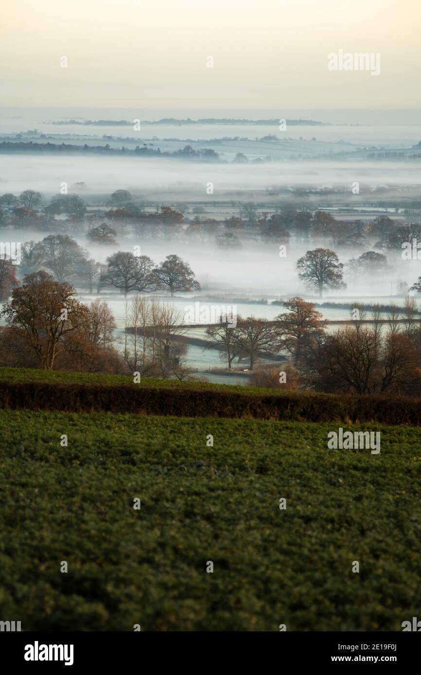 Misty countryside scene with layers of mist in a valley with hills ...