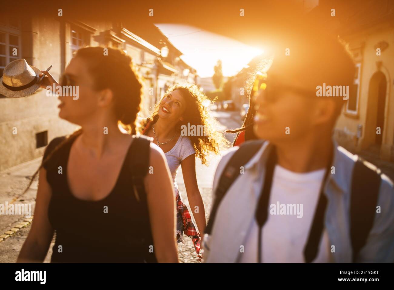 Joyful moment of a two couples walking down the street on a sunset ...