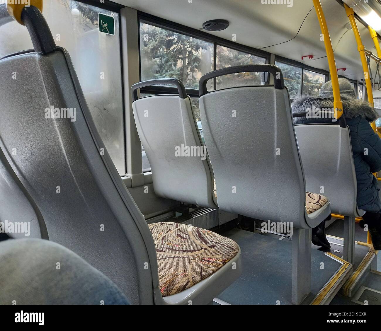 City bus interior, public transport concept. Adult woman riding the bus ...