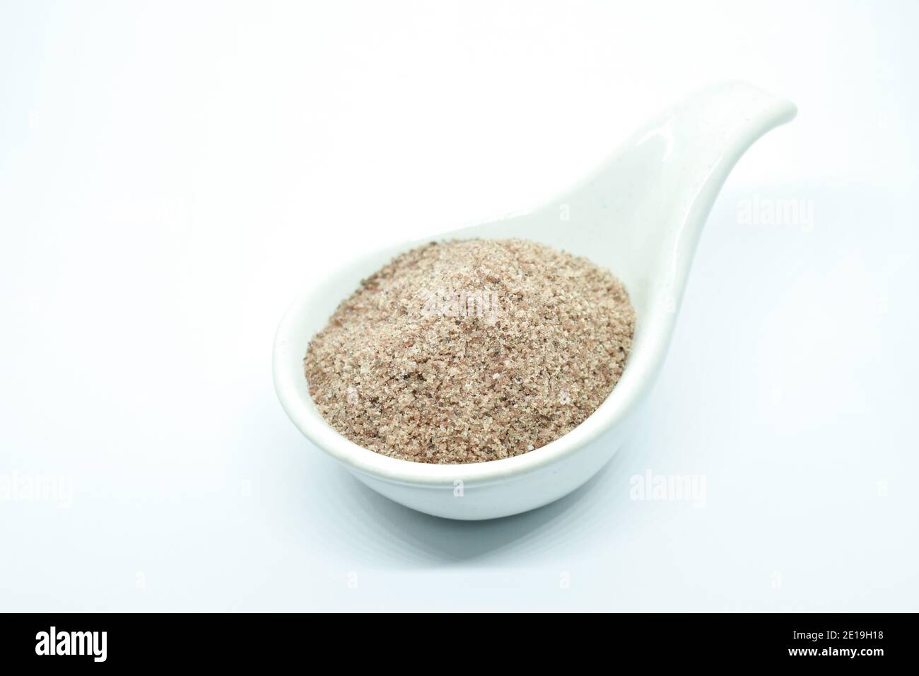 Himalayan black salt or volcanic rock salt on spoon in white background ...