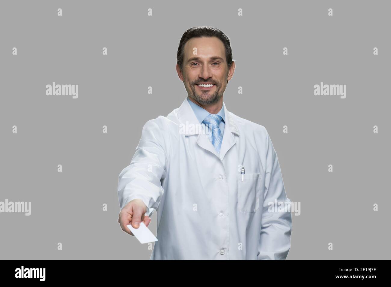 Successful male doctor offering business card Stock Photo - Alamy