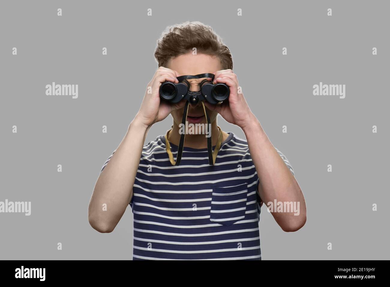 Caucasian teen boy looking through binoculars Stock Photo - Alamy