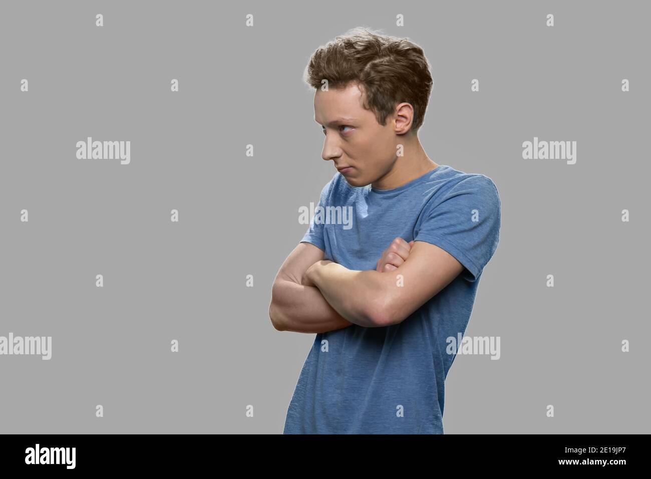 Side view of upset teen boy with arms crossed Stock Photo - Alamy
