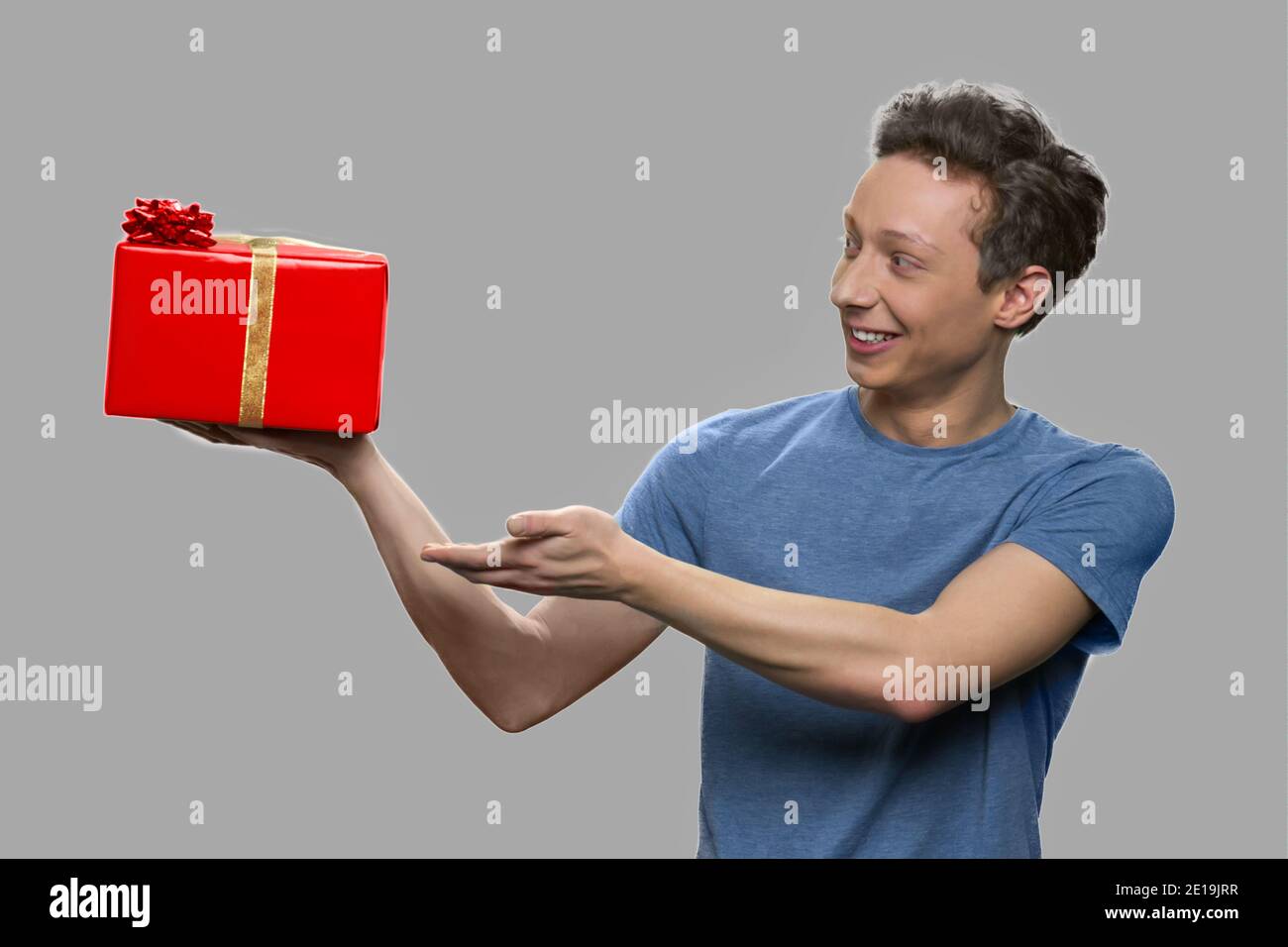 Smiling boy showing gift box in his hand Stock Photo - Alamy