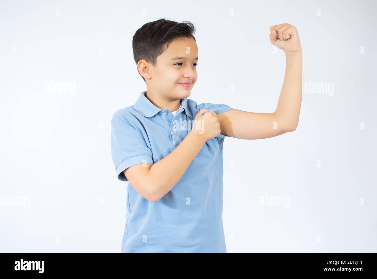 Boy is showing his arm muscles over white background Stock Photo - Alamy Boy is showing his arm muscles over white background Stock Photo - Alamy