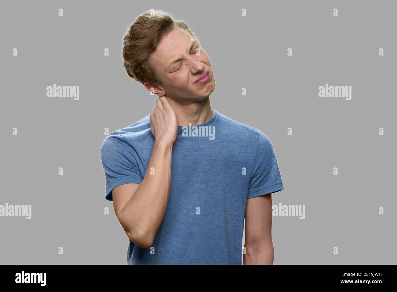 Teen boy having neck pain Stock Photo - Alamy