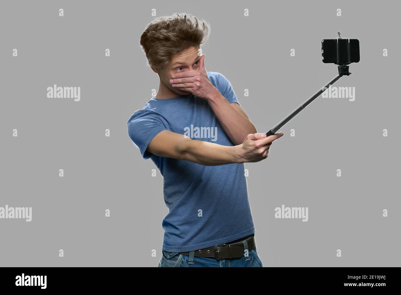 Funny teen boy taking selfie with selfie stick Stock Photo - Alamy