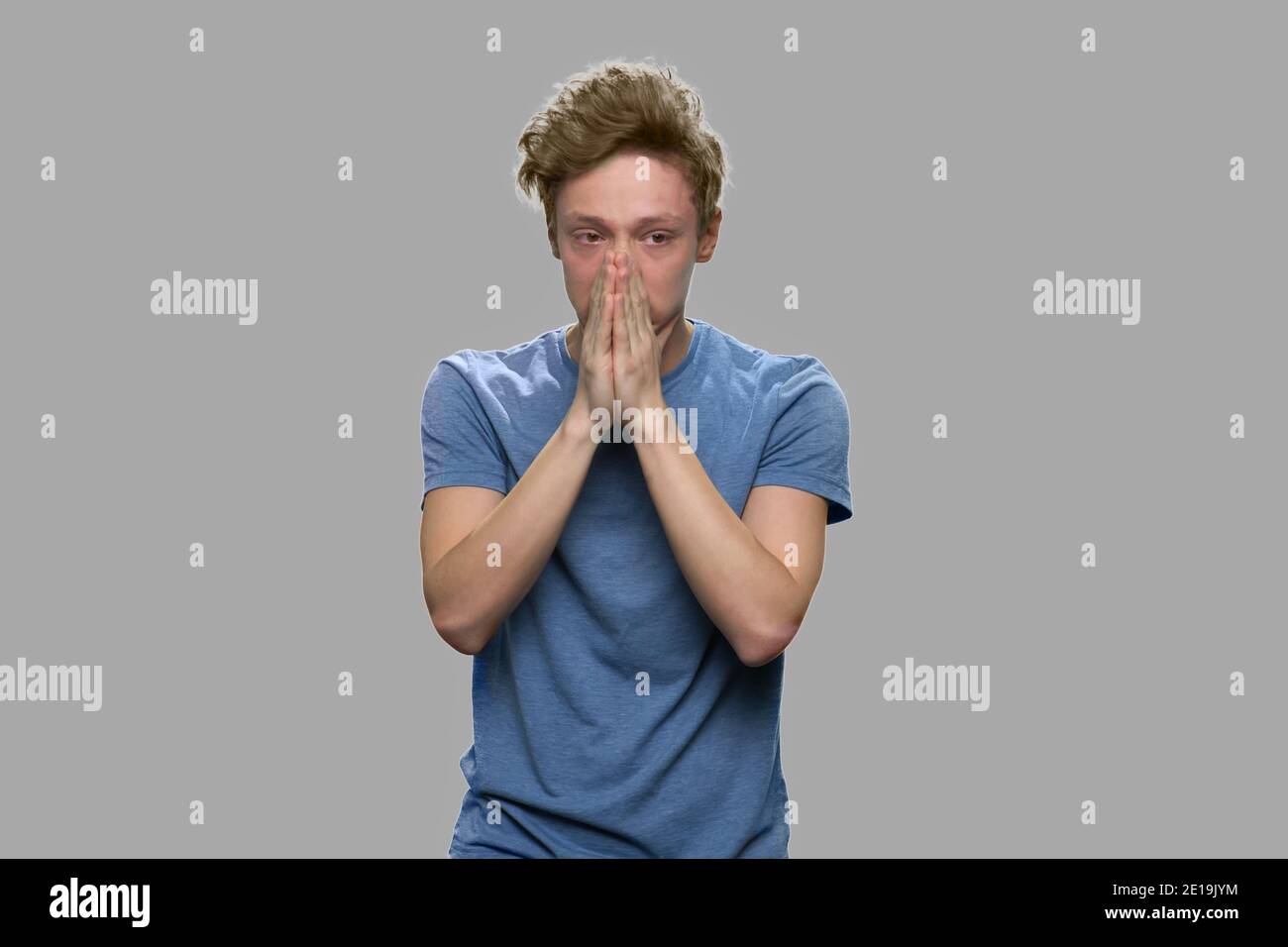 Unhappy stressed teenage boy on gray background Stock Photo - Alamy