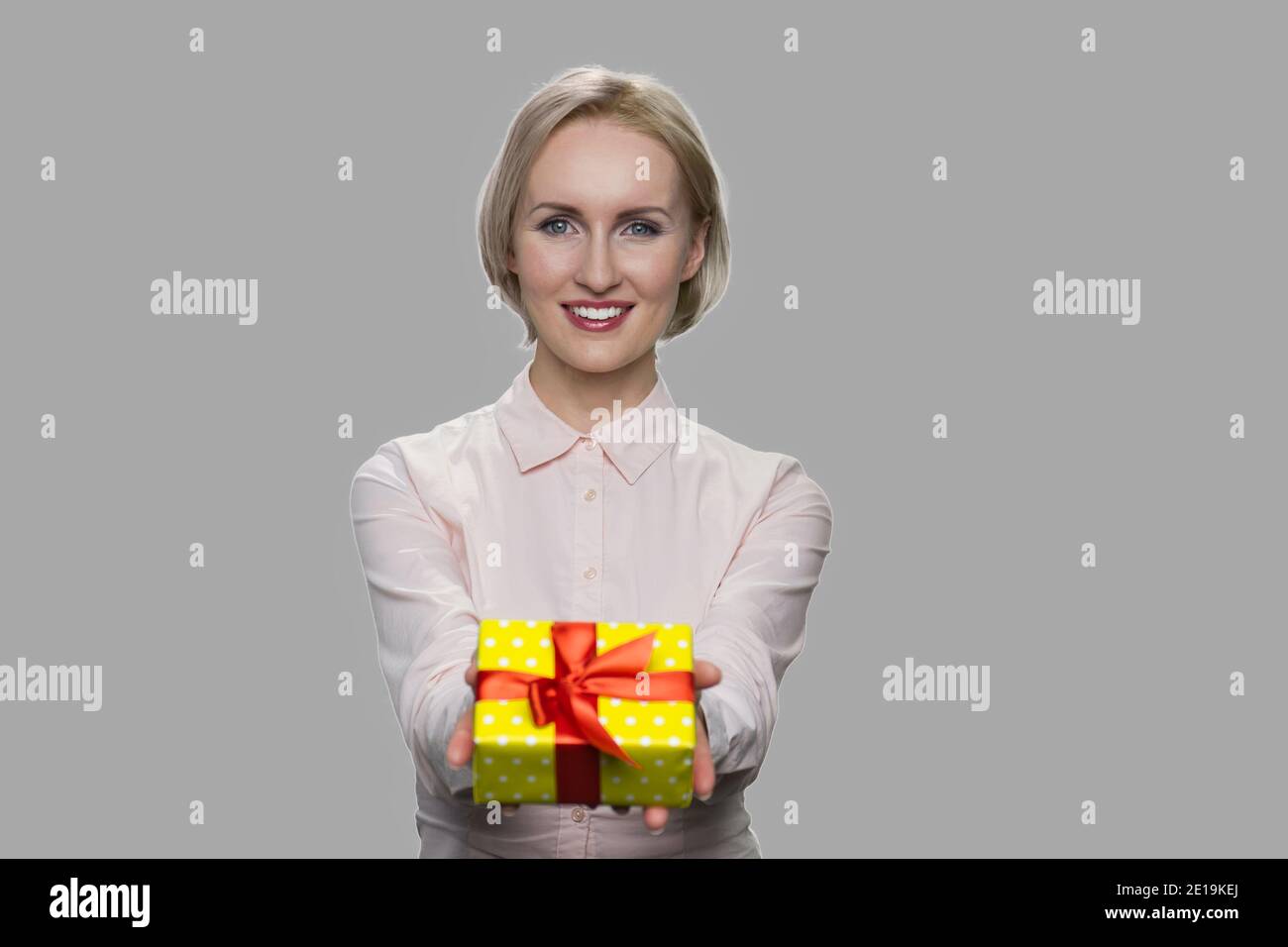 Pretty caucasian woman giving gift box Stock Photo - Alamy
