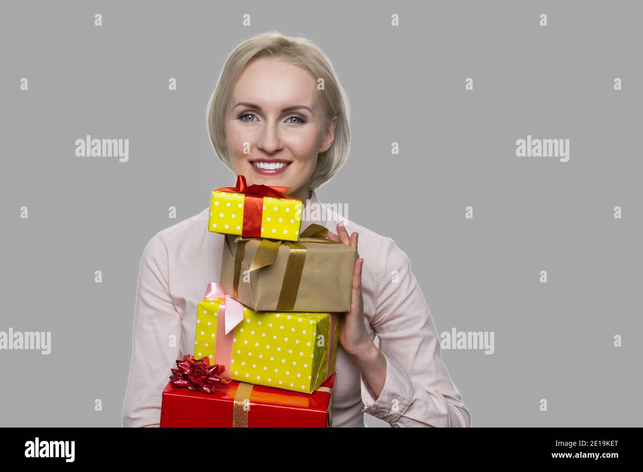Portrait of pretty woman with pile of gift boxes Stock Photo - Alamy