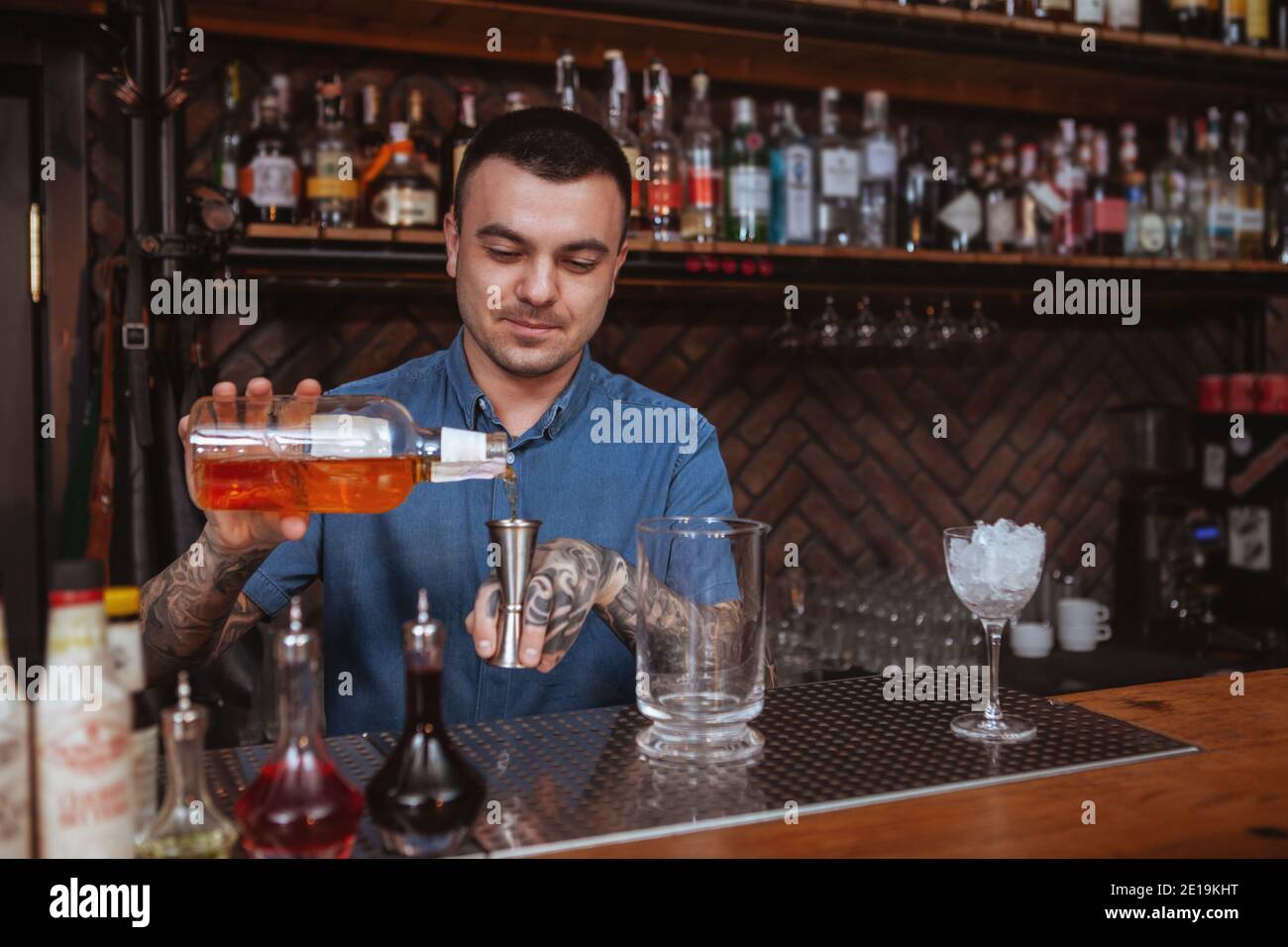Handsome cheerful bartender enjoying working at his bar, making ...