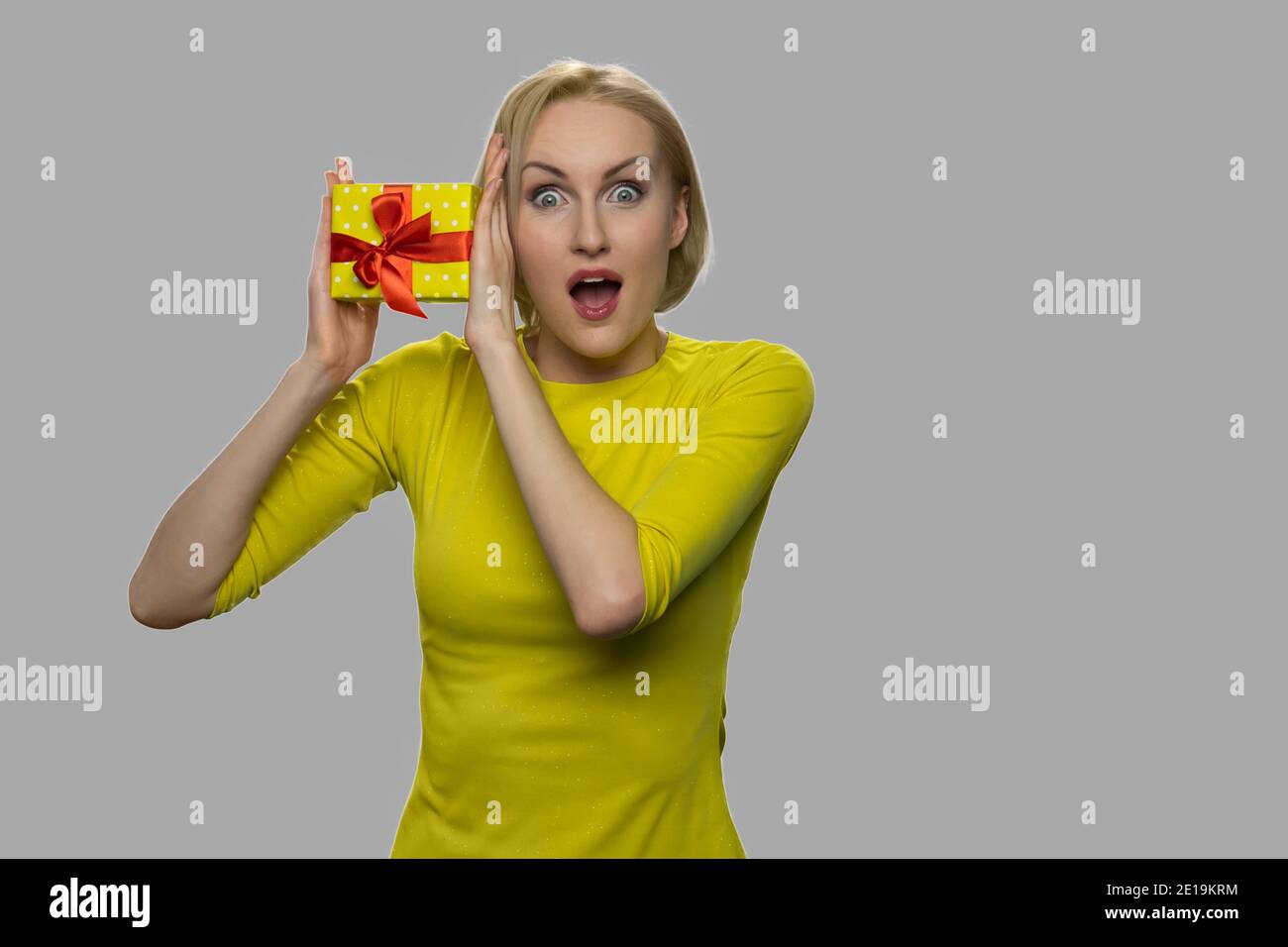 Happy shocked woman holding gift box Stock Photo - Alamy