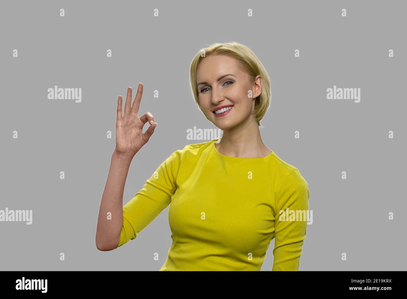 Beautiful woman showing okay sign with fingers Stock Photo - Alamy