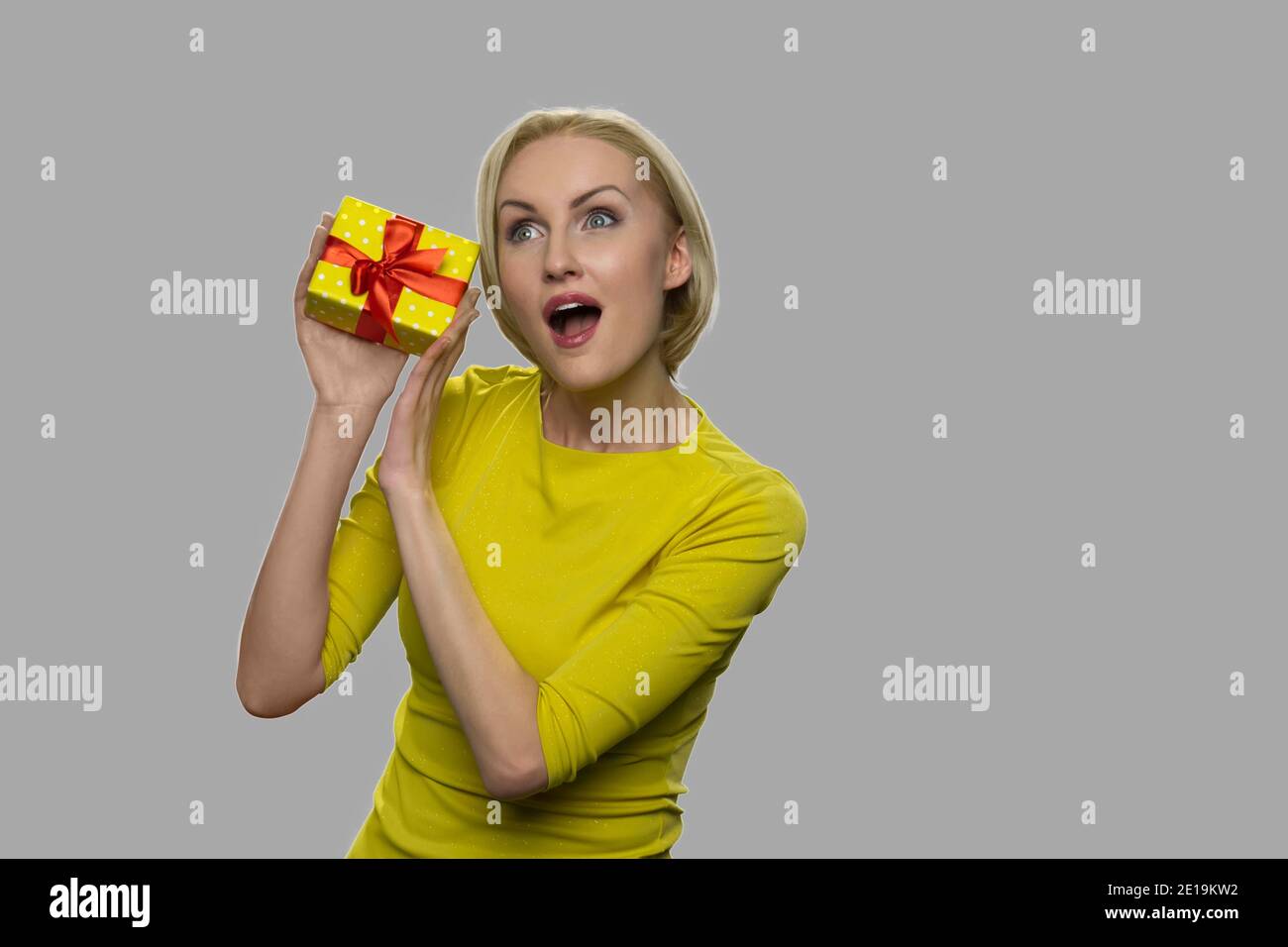 Woman shaking gift box hi-res stock photography and images - Alamy