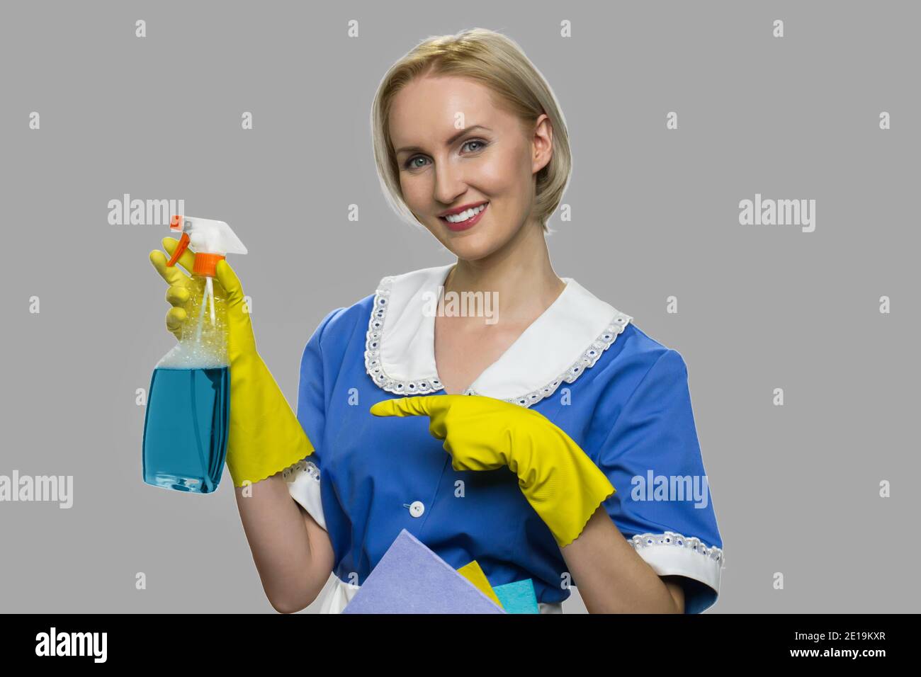 Cleaning woman in uniform presenting detergent Stock Photo - Alamy