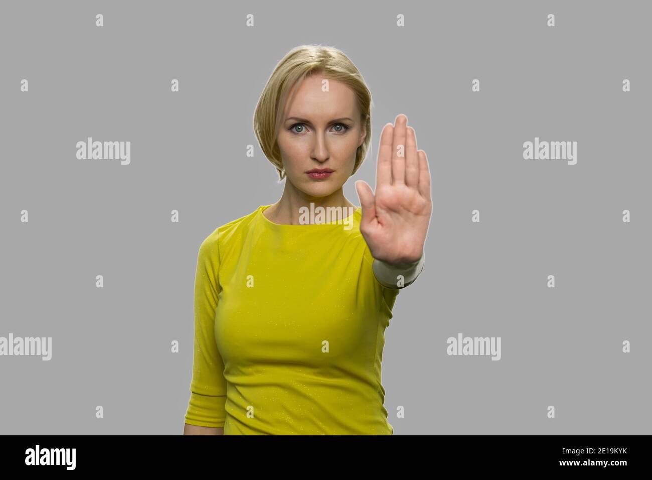 Serious blonde woman stop gesture hi-res stock photography and images ...