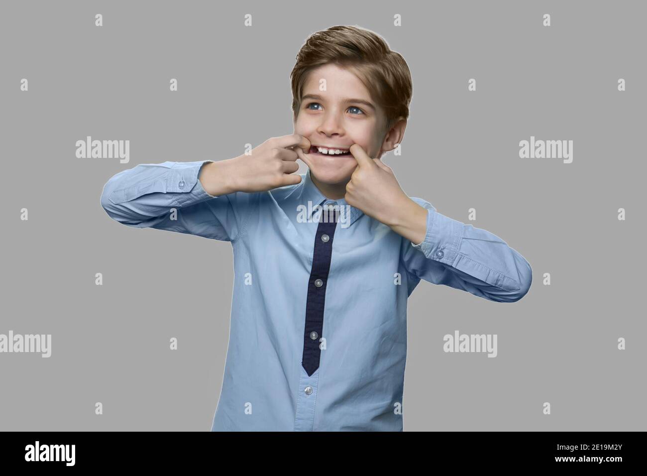 Child boy making funny pulling face with fingers in mouth Stock Photo ...