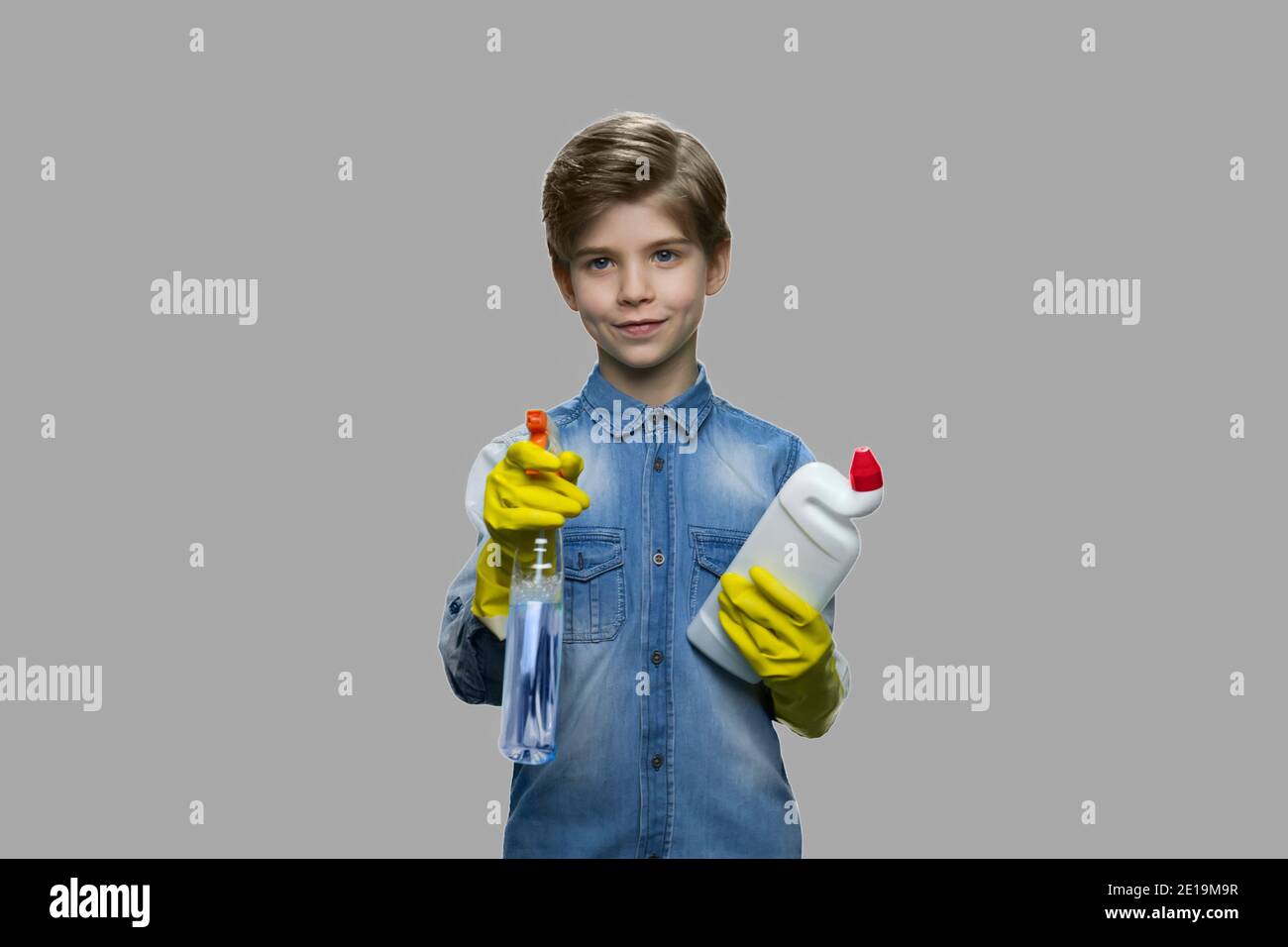 Cute boy holding cleaning supplies Stock Photo - Alamy
