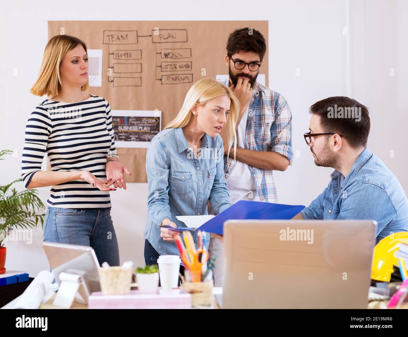Frustrated boss having a conversation with scared employees while ...