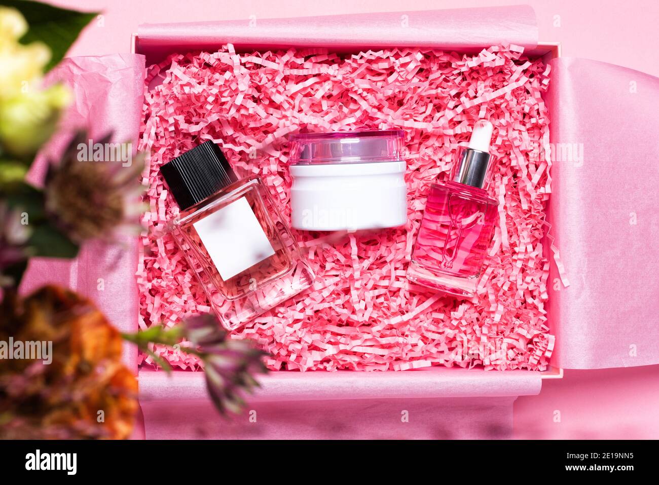 Beauty box with cosmetics filled with shredded pink paper packing ...