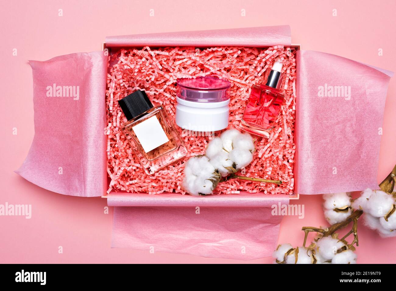 Beauty box with cosmetics filled with shredded pink paper packing ...