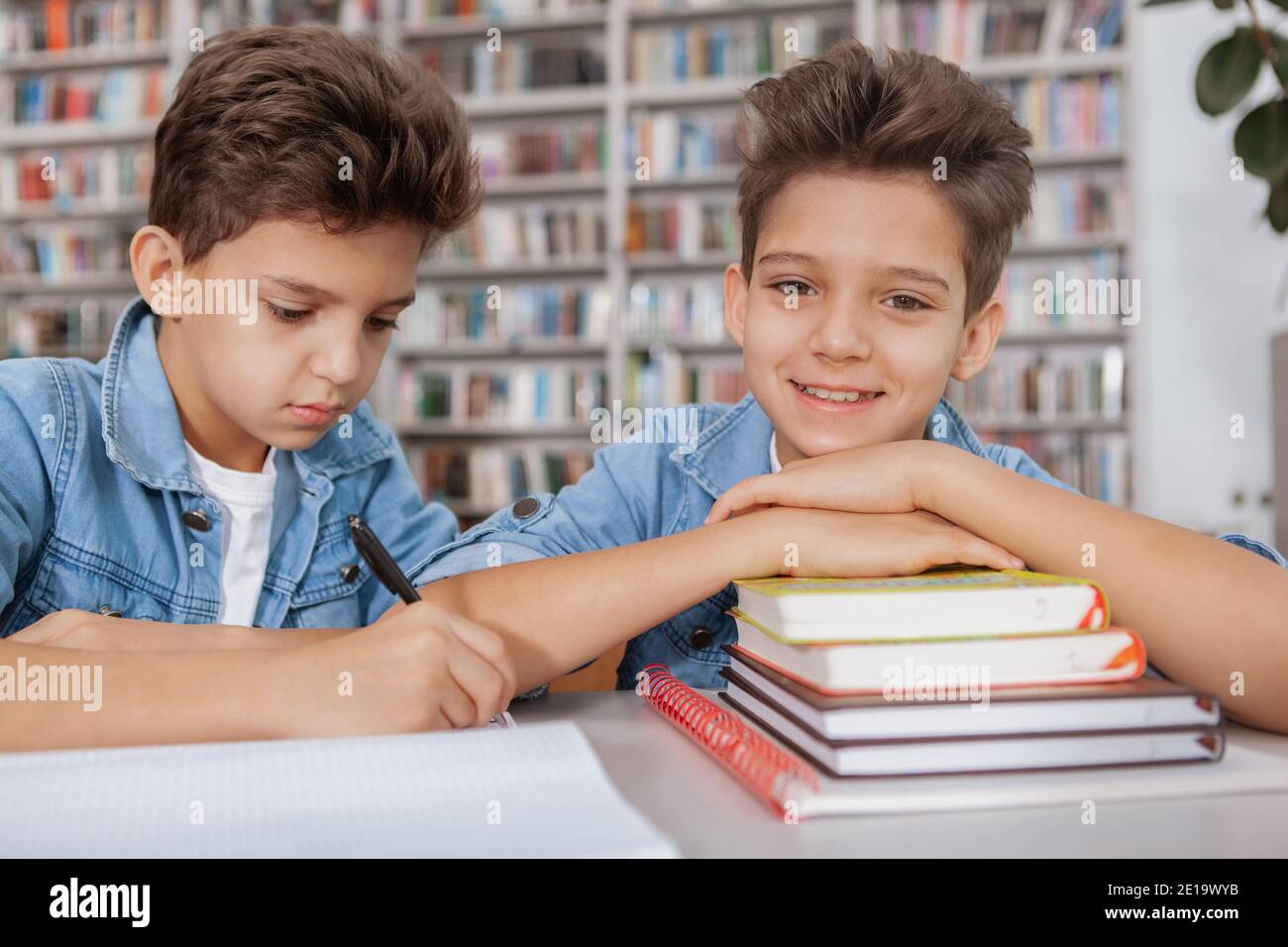 CUte happy young boy smiling to the camera while his twin brother ...