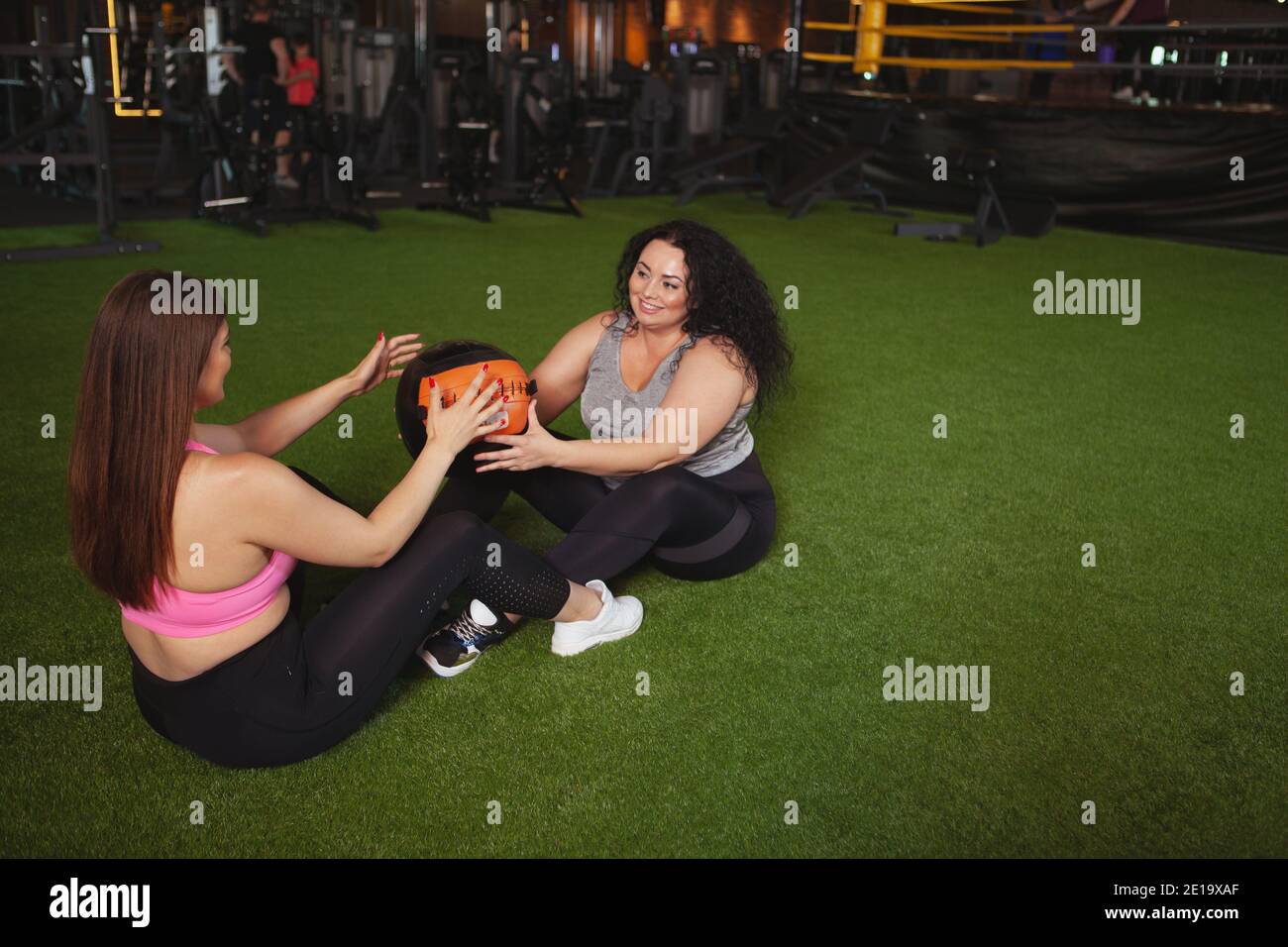 Top view shot of two plus size sportswomen exercising with medicine ...