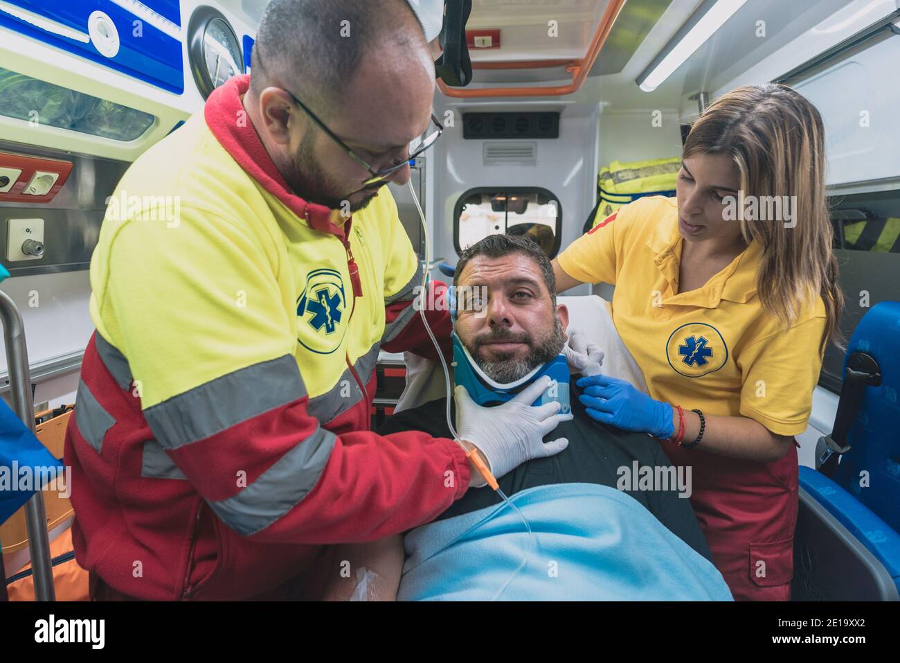 a medical team in an ambulance helps an adult man Stock Photo - Alamy