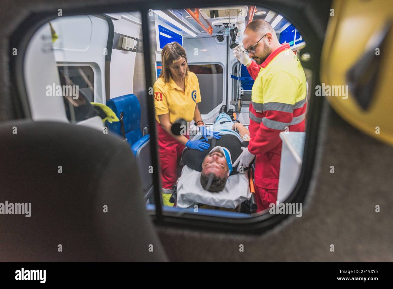 a medical team in an ambulance helps an adult man Stock Photo - Alamy