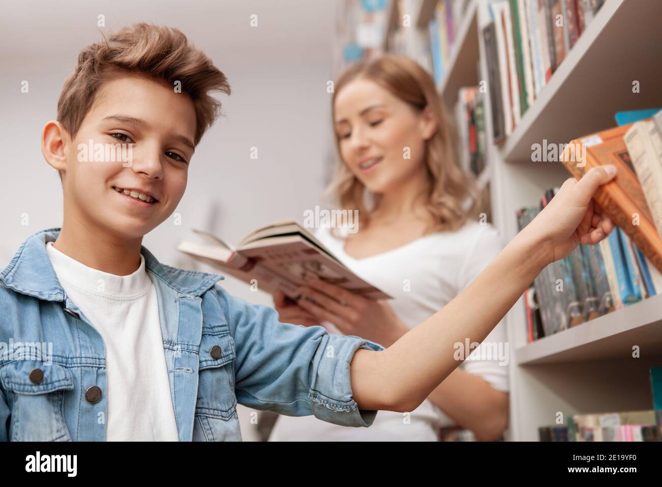 Schoolboy taking book shelf school library hi-res stock photography and ...