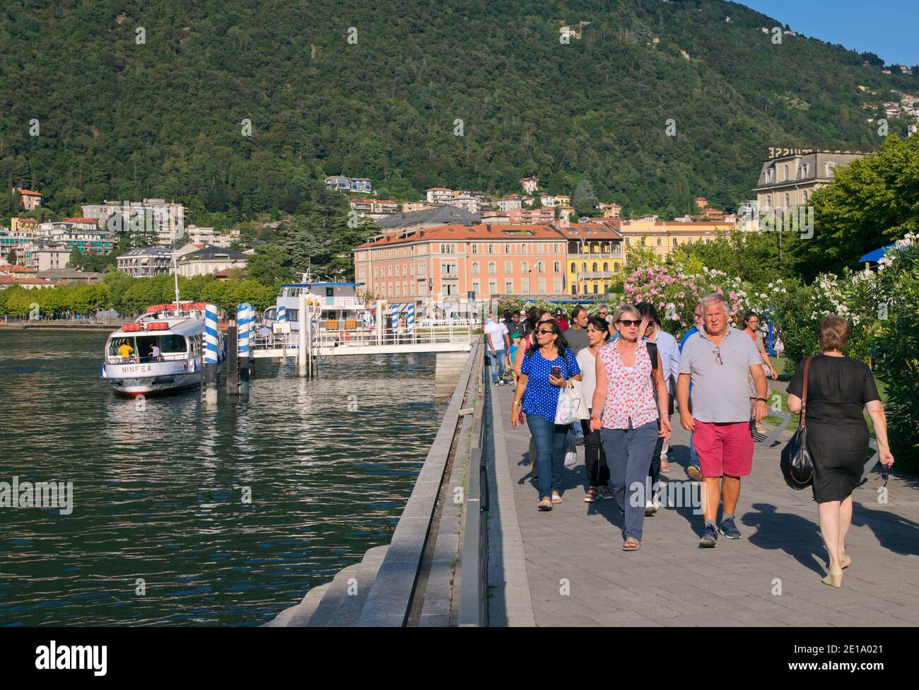 tourists walking along the waterfront promenade in the city of Como ...