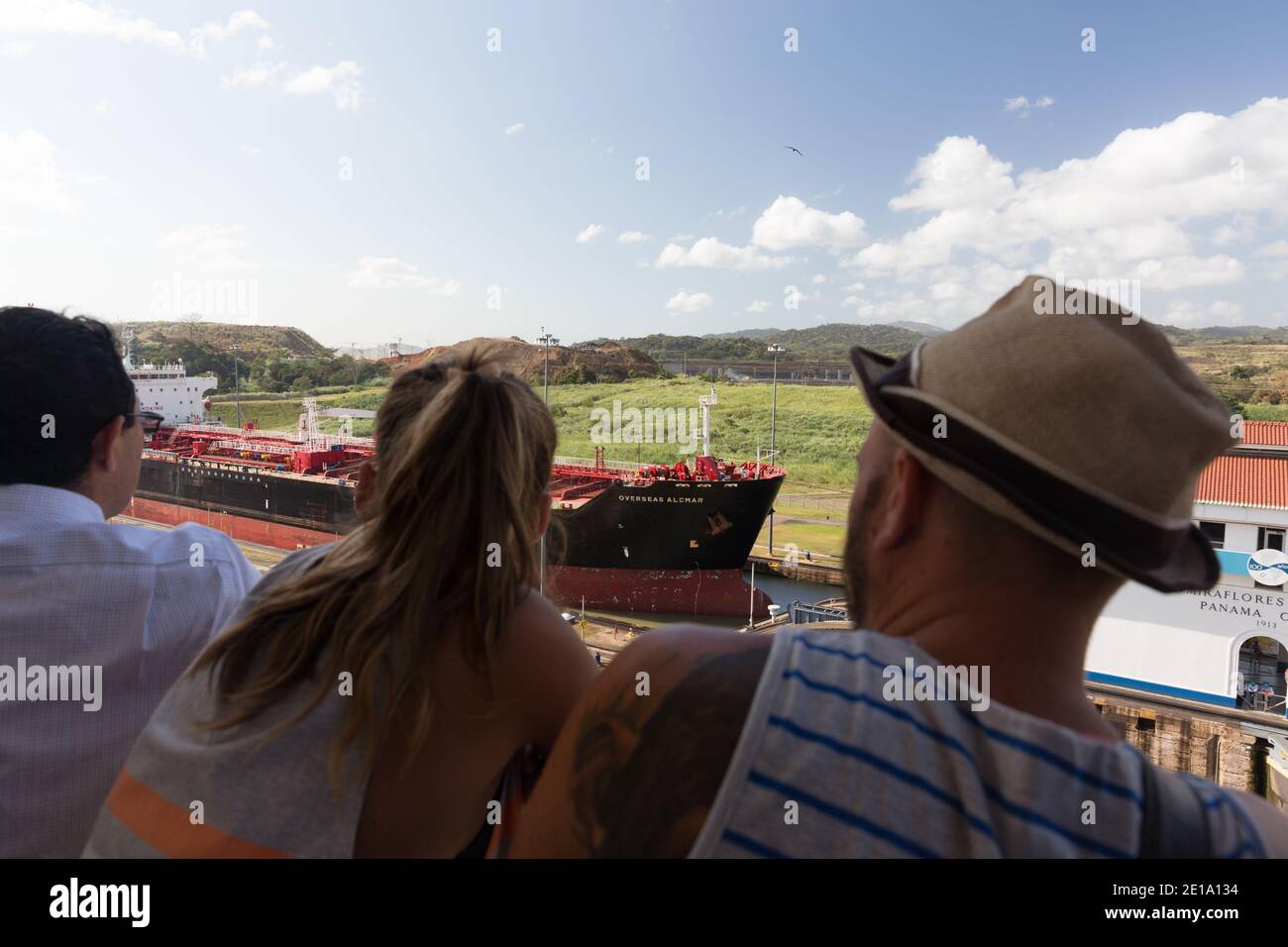 Visitors watch a tanker ship pass through the Miraflores Locks of the ...