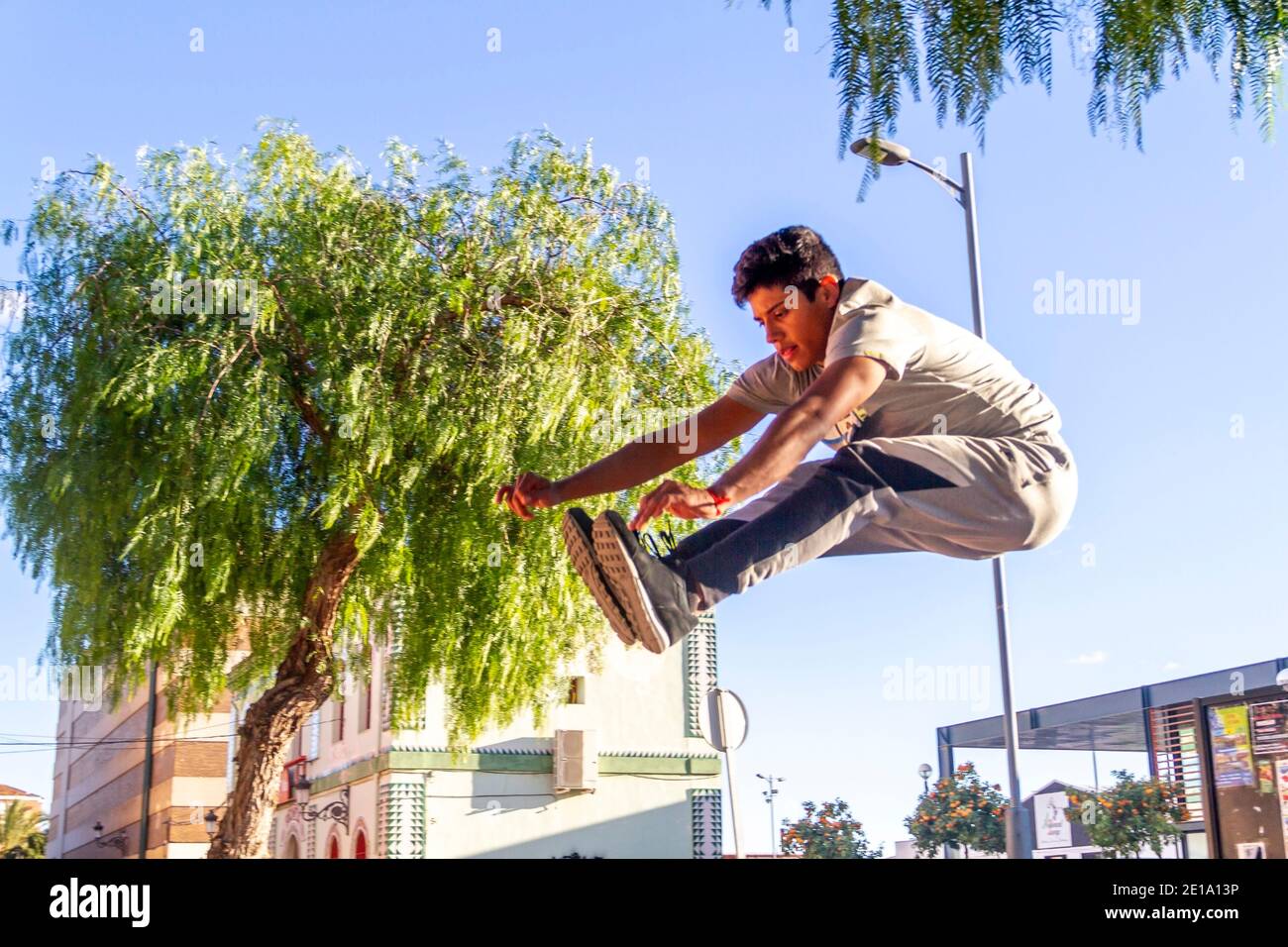 Active Latino young man jumping in action. Extreme sport activity ...