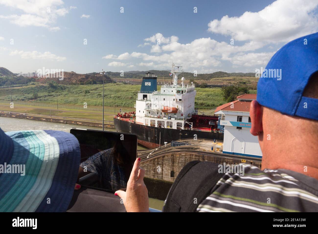 Visitors watch a tanker ship pass through the Miraflores Locks of the ...