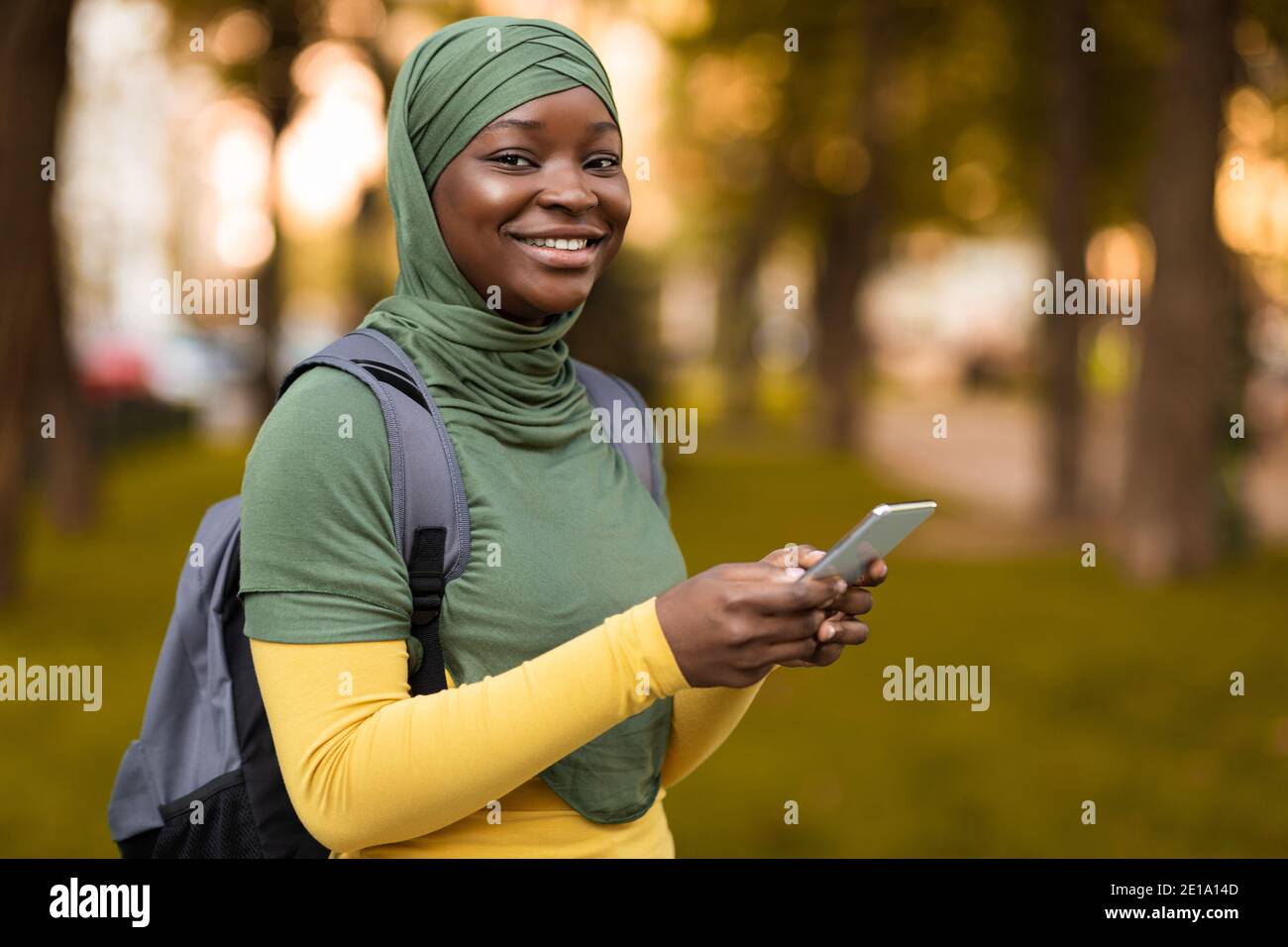 Outdoor Portrait Of Happy Black Muslim Female Student With Smartphone ...
