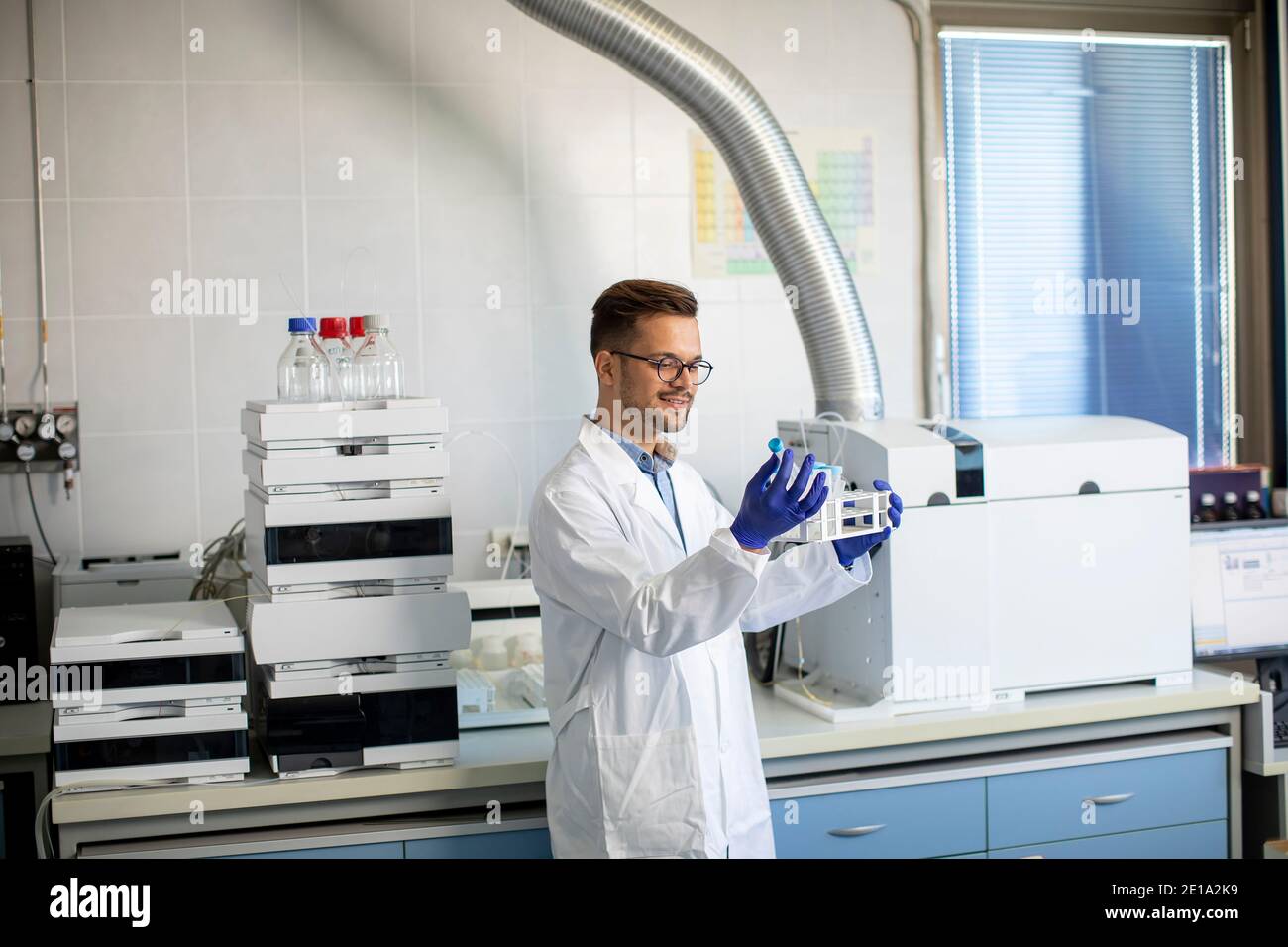 Handsome young researcher workin with chemical samples in laboratory ...