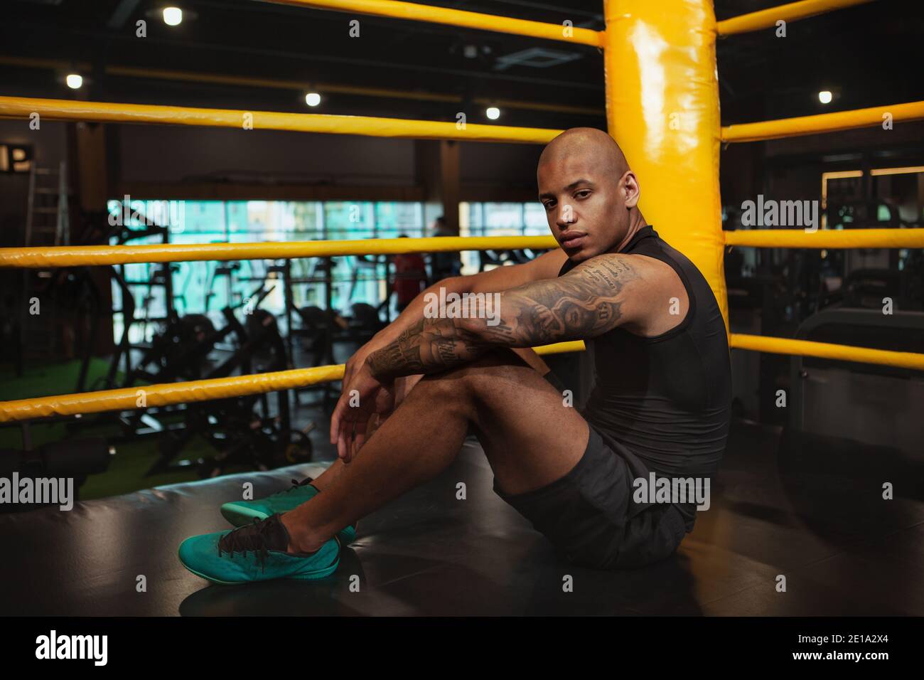Full length shot of a handsome African male boxing fighter sitting in ...