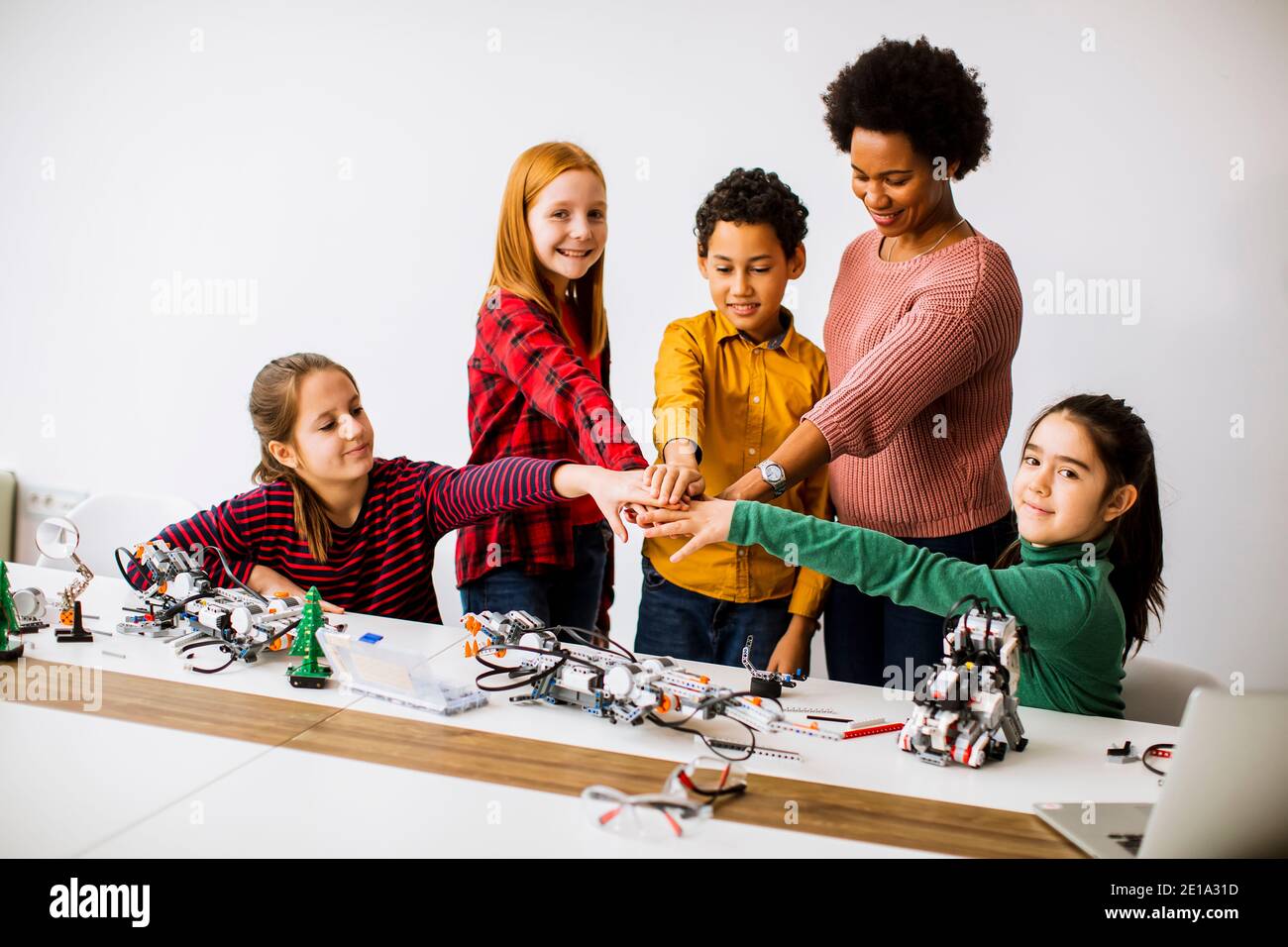 Group of happy kids with their African American female science teacher ...