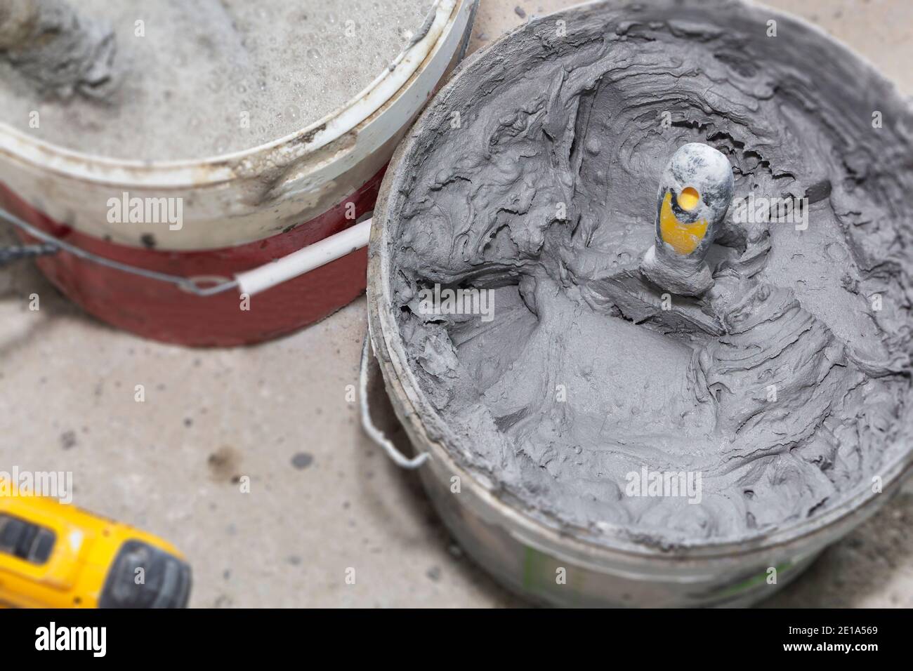 Decorative cement plaster and a trowel in a construction bucket ready ...