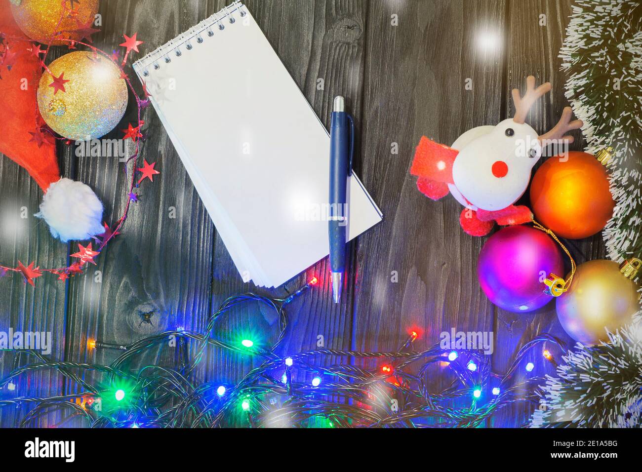Christmas toys on a wooden gray background, and a Notepad with a pen ...