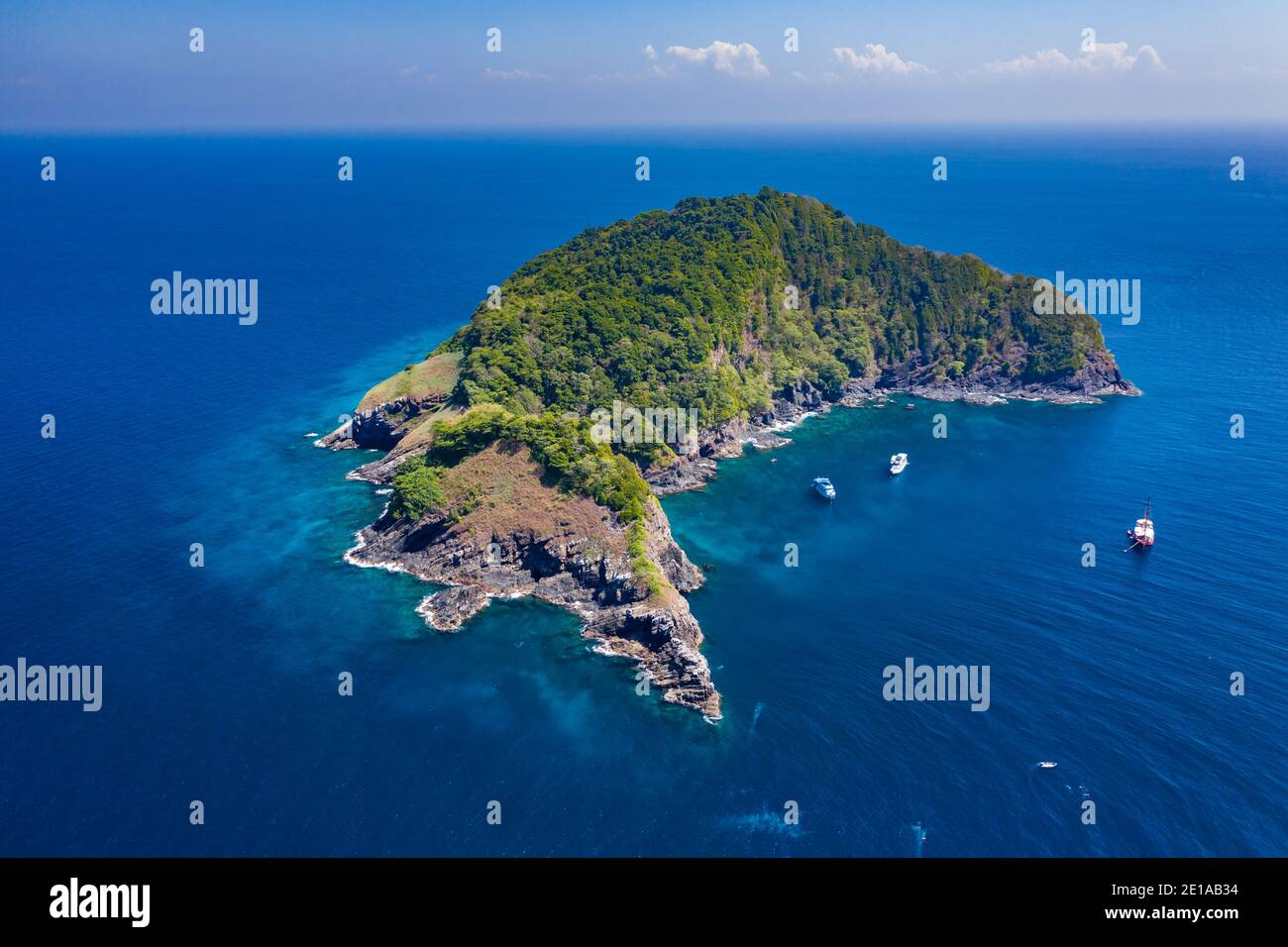 Aerial drone view of boats around a beautiful, remote tropical island ...