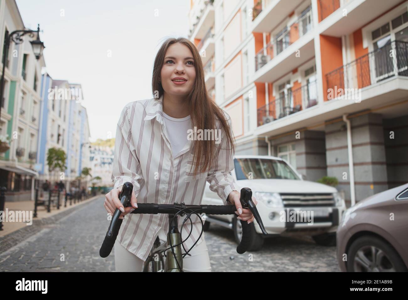 Happy beautiful woman riding her bicycle on city streets Stock Photo ...