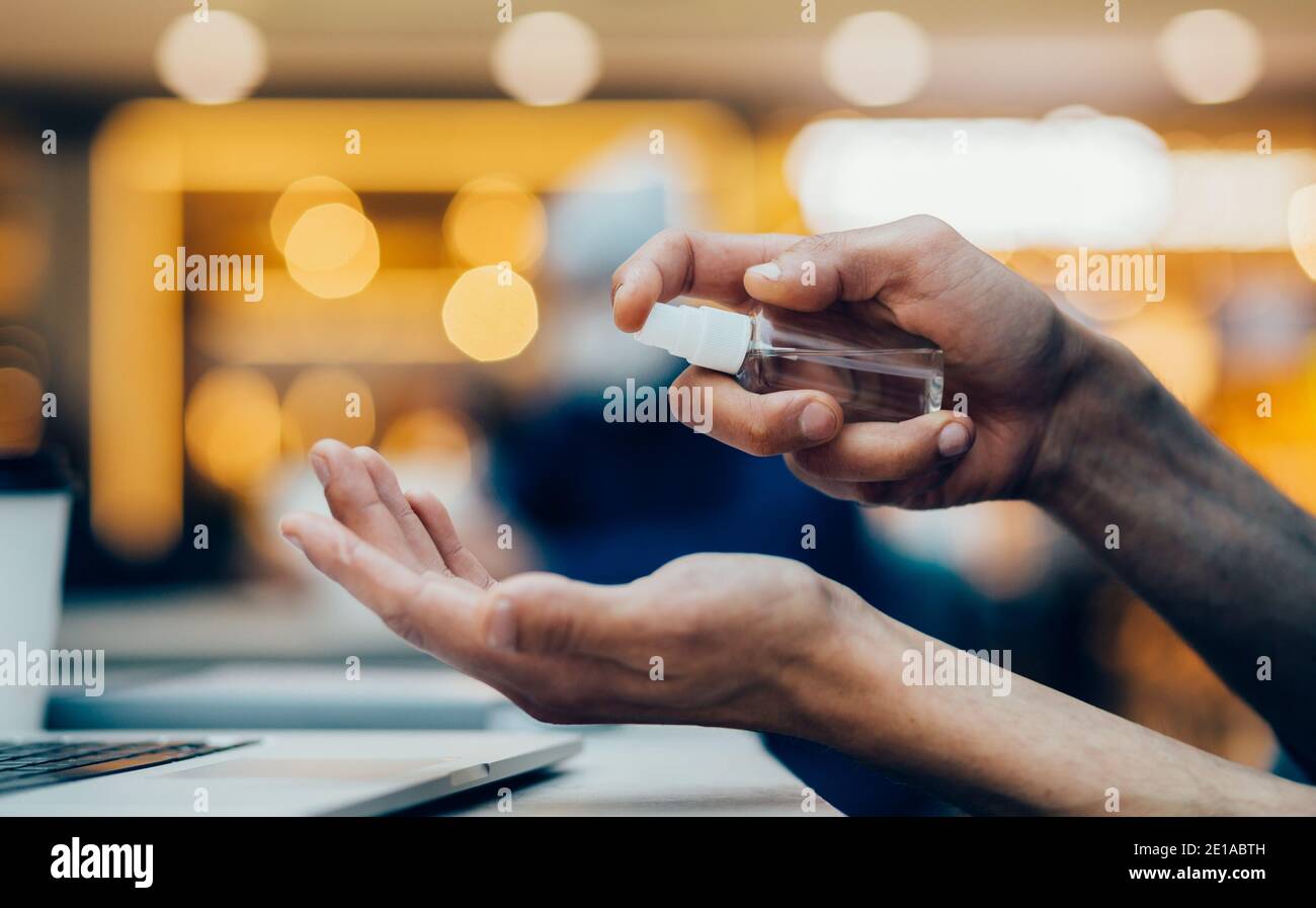 close up. man spraying antiseptic hand spray Stock Photo - Alamy